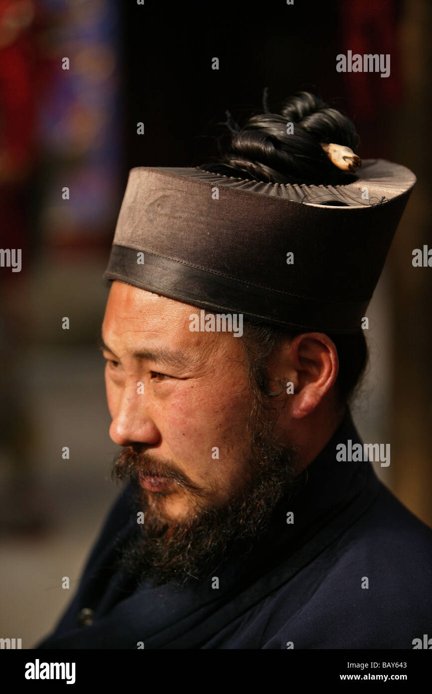 Taoist monk wearing headwear for long hair with an opening for plaits ...