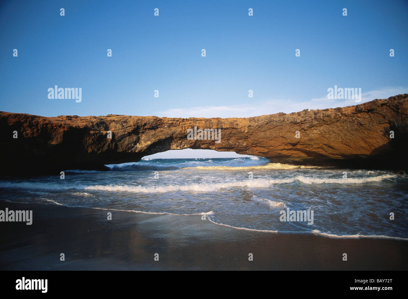 Rock bridge at a lonely beach, Aruba, Netherlands Antilles Stock Photo ...