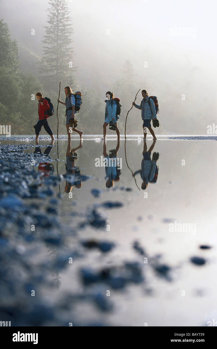 Hikers crossing a river Stock Photo - Alamy