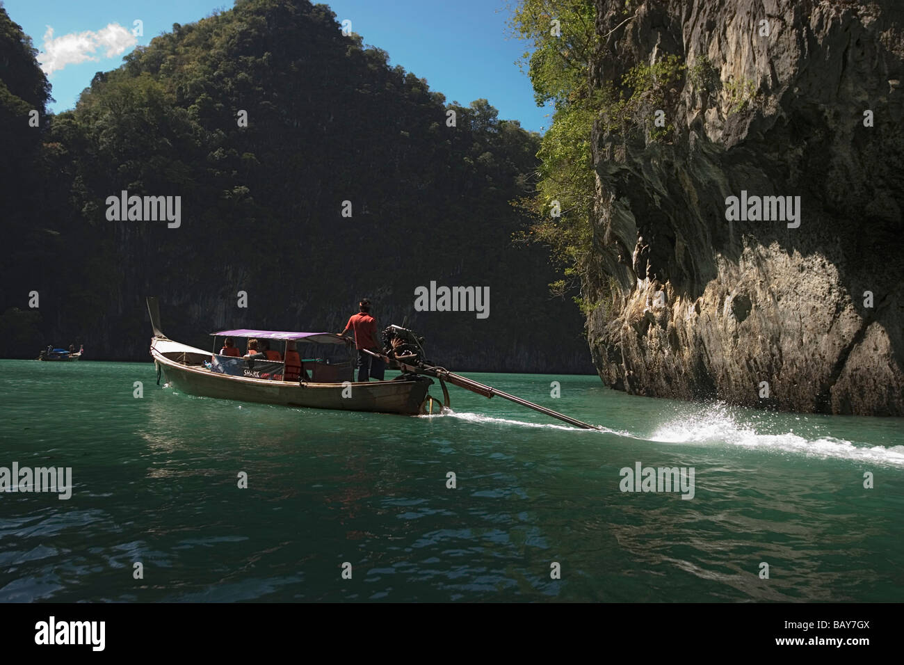 People driving a boat through Ko Hong Island lagoon, Krabi, Thailand ...