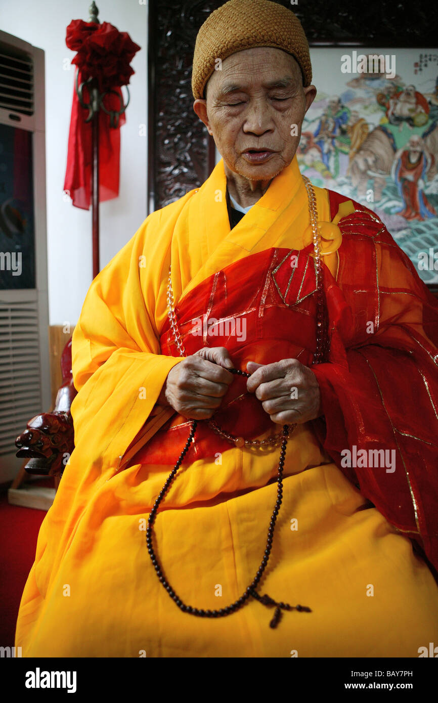 Praying abbot of Baotan Si monastery with prayer beads, Nantai, Heng ...