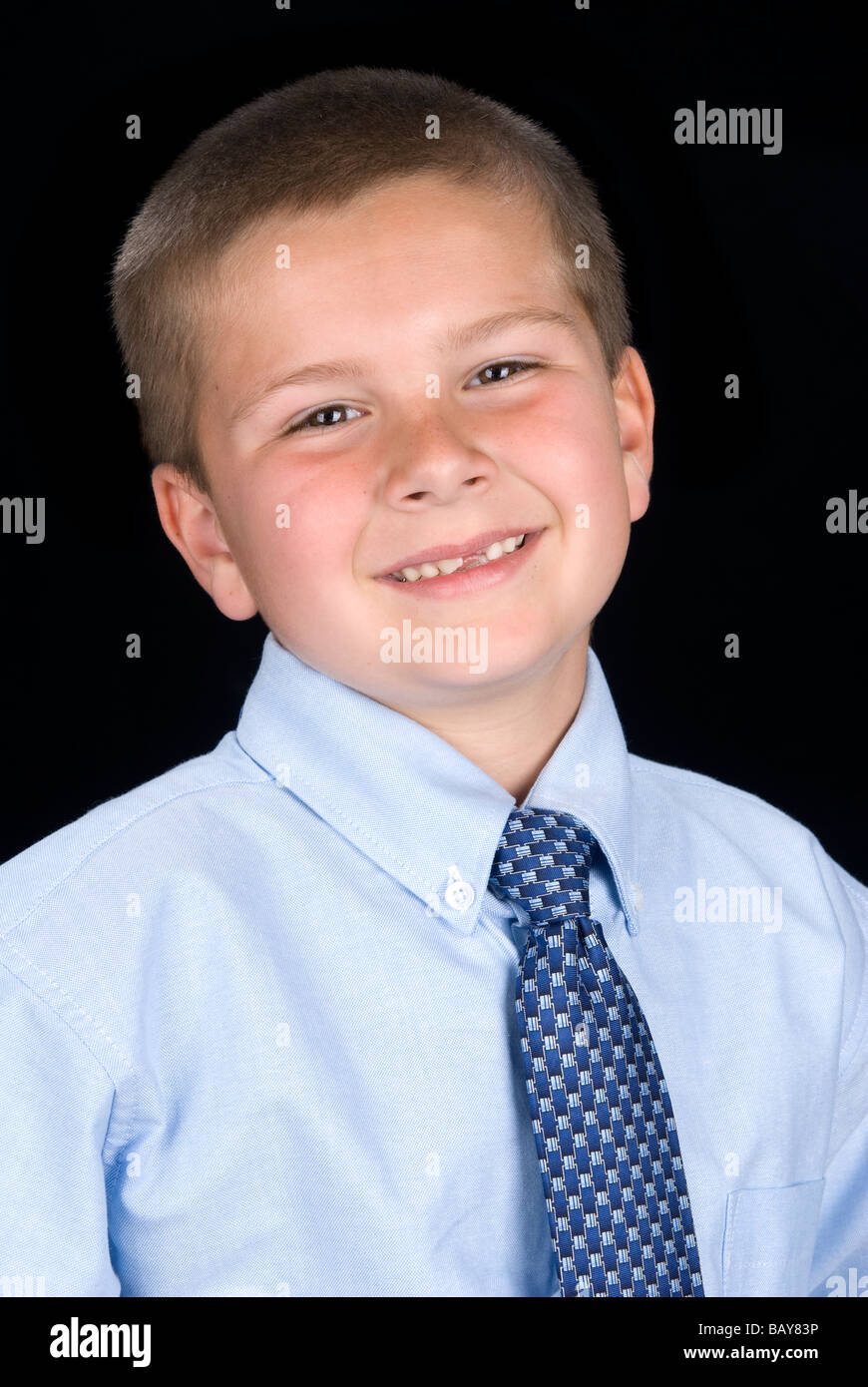 A portrait of a young boy in a shirt and necktie Isolated on a black ...