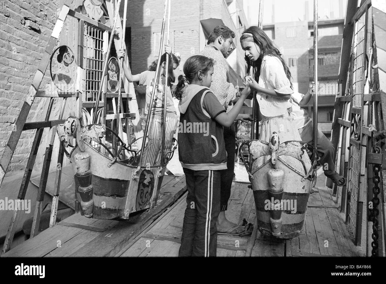 Egyptian children about to enjoy a hand-powered swing i Coptic Easter ...