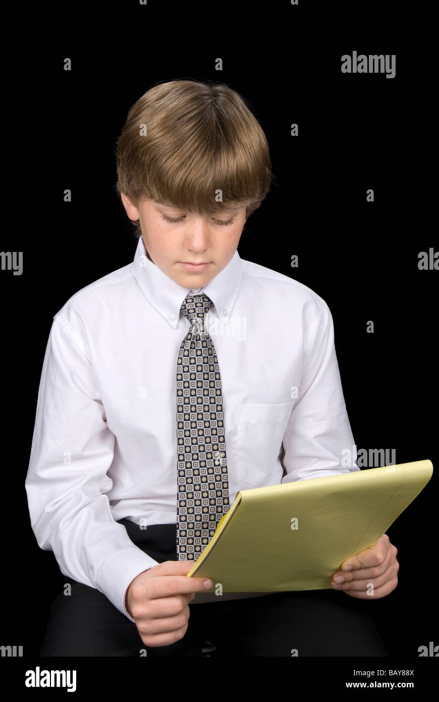 A young boy in formal business dress reads his notepad Stock Photo - Alamy