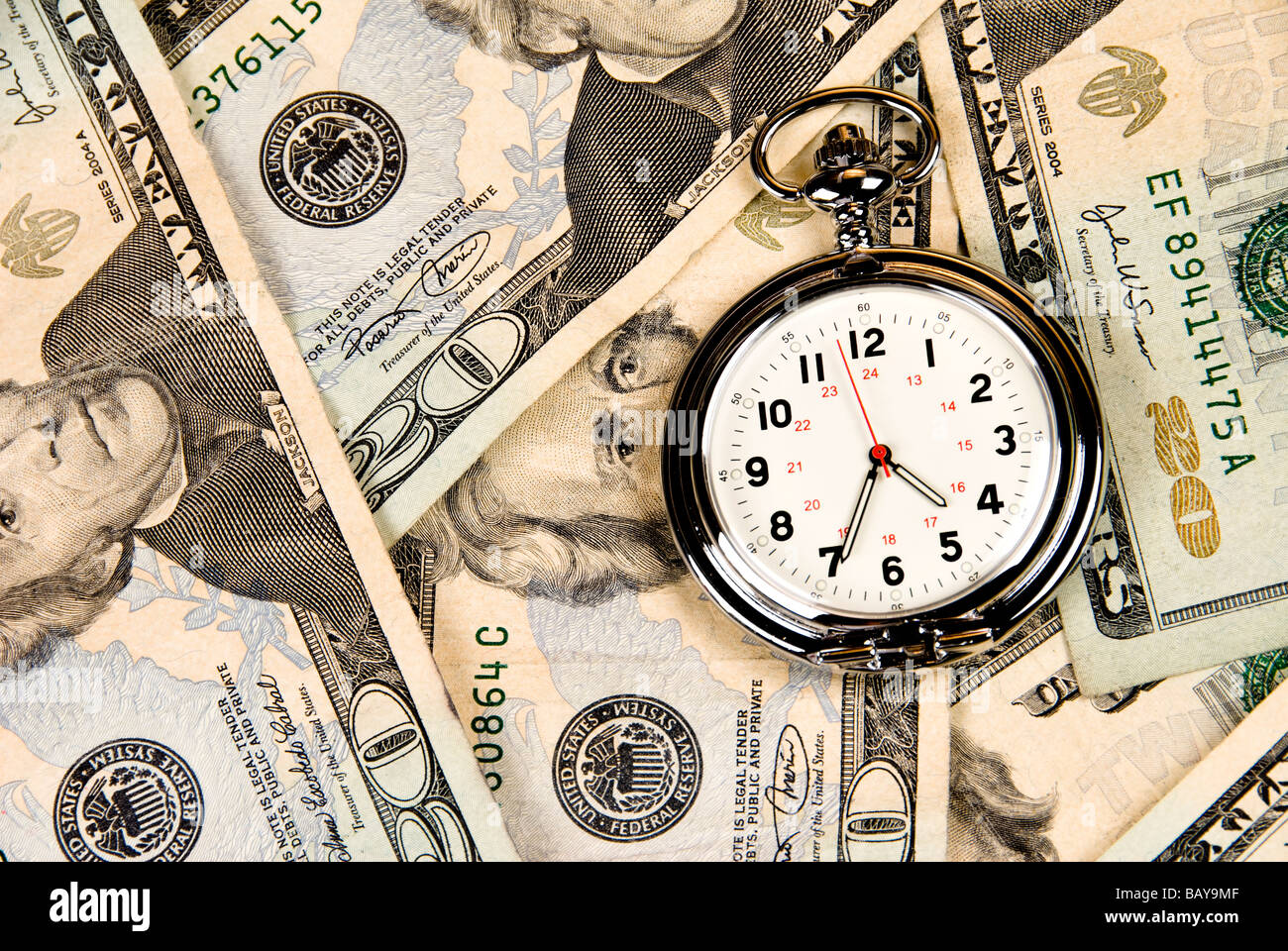 USA currency with a pocket watch on top inferring financial growth over ...