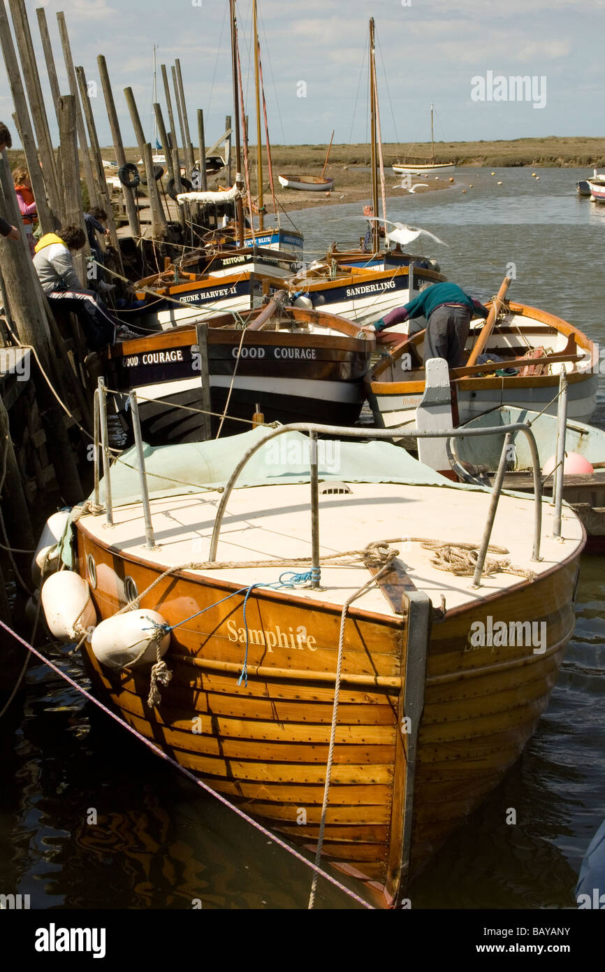 Traditional working boats moored alongside wooden quay at Blakeney ...