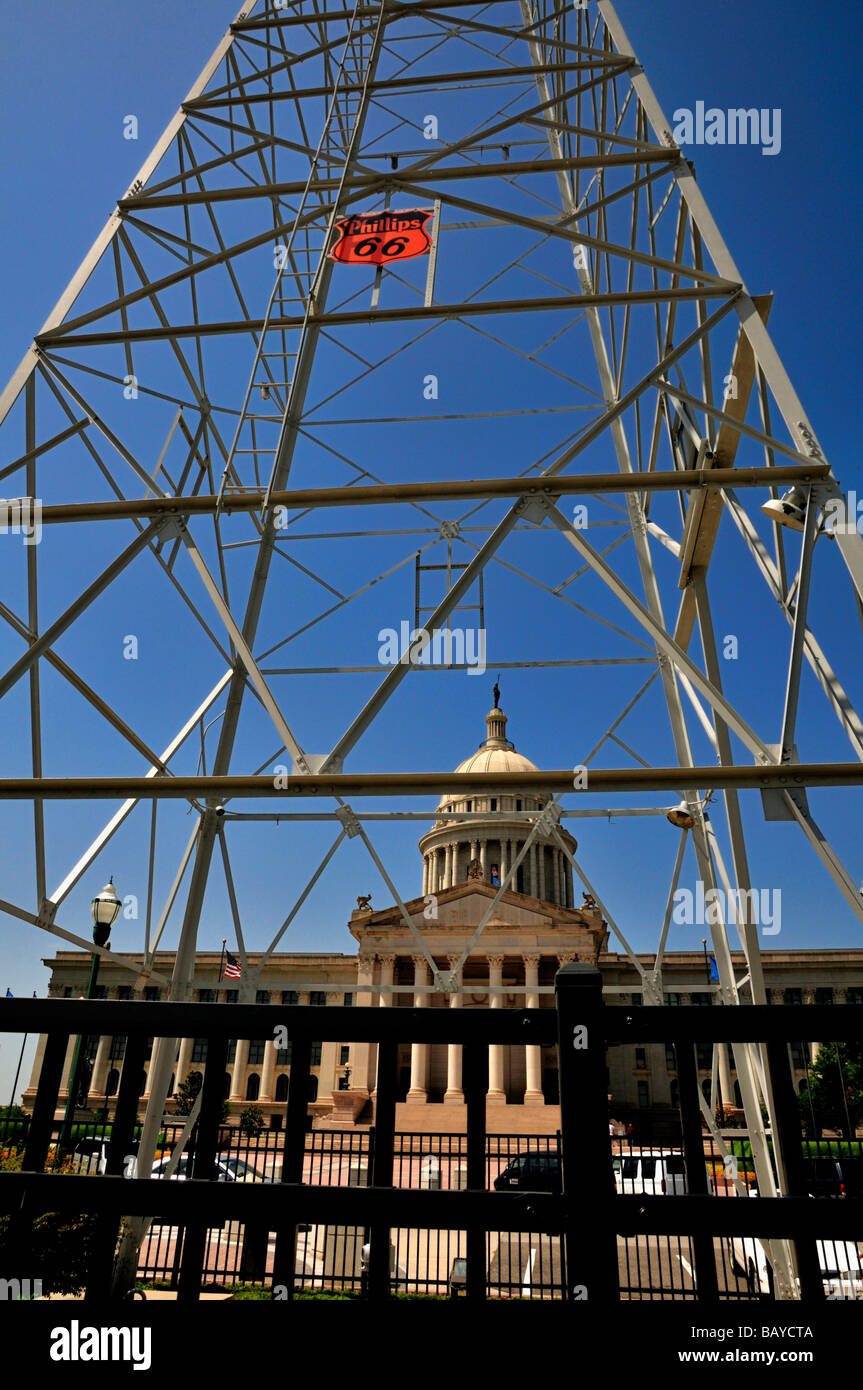 An oil derrick stands in front of the Oklahoma capitol building ...