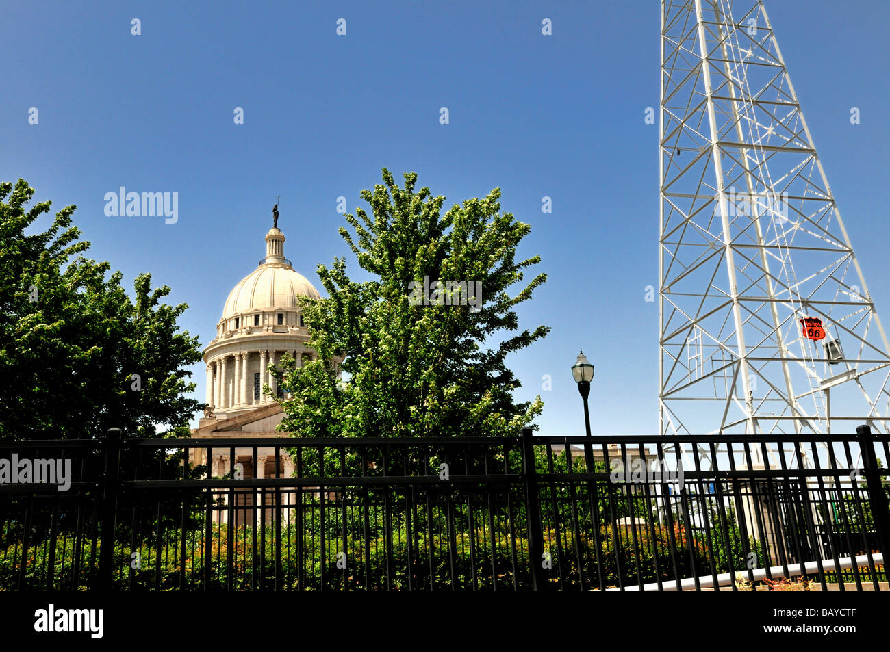 An oil derrick stands in front of the Oklahoma capitol building ...