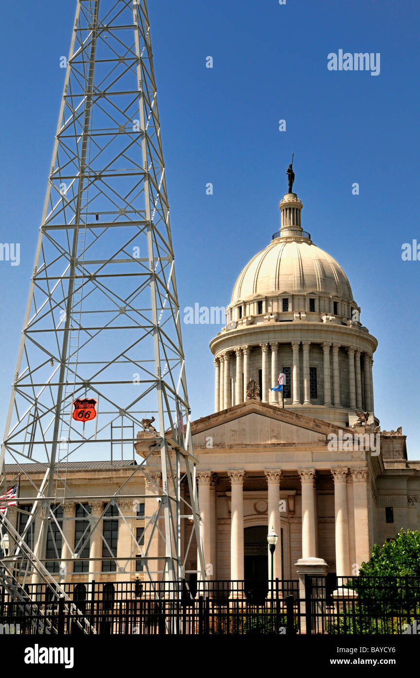 An oil derrick stands in front of the Oklahoma capitol building ...