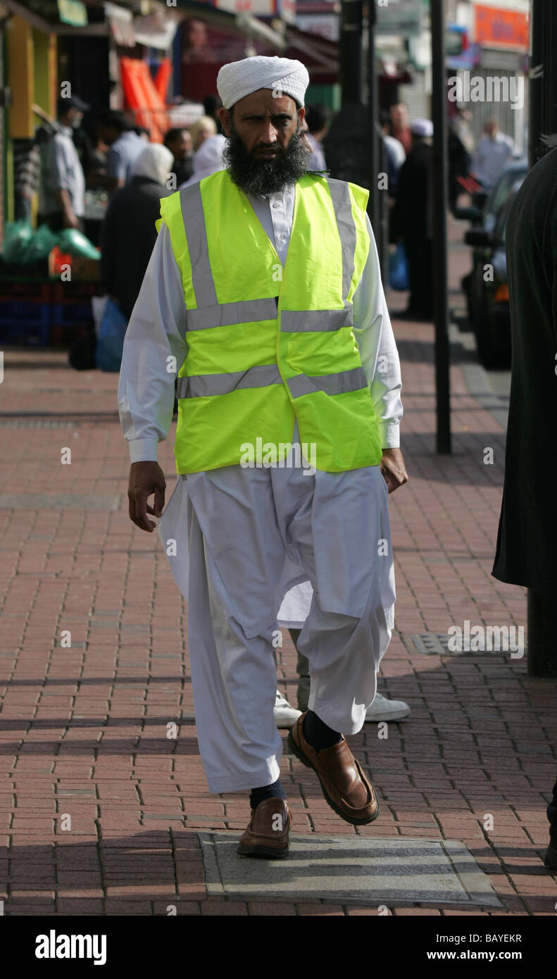 A Muslim man in traditional clothes wearing a thoroughly modern ...