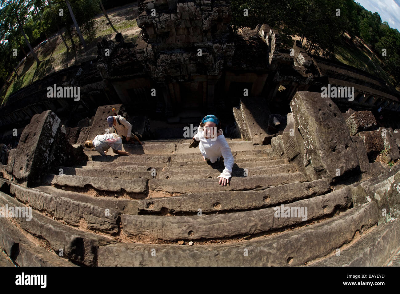 Tourist on temple stairs in ancient city of Angkor; Angkor Wat, Siem ...