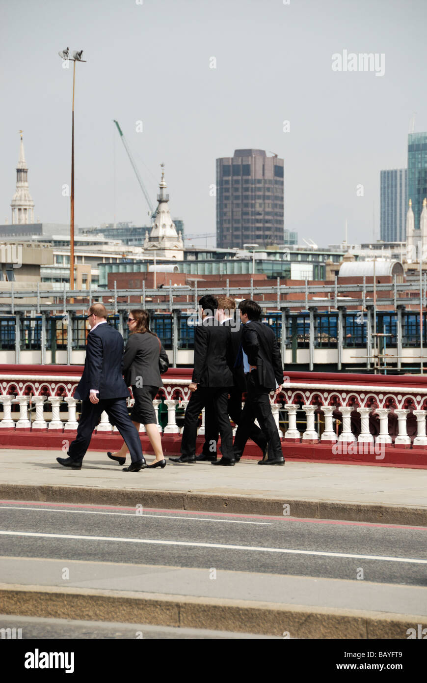 Five business people in suits passing over Blackfriars bridge in the ...