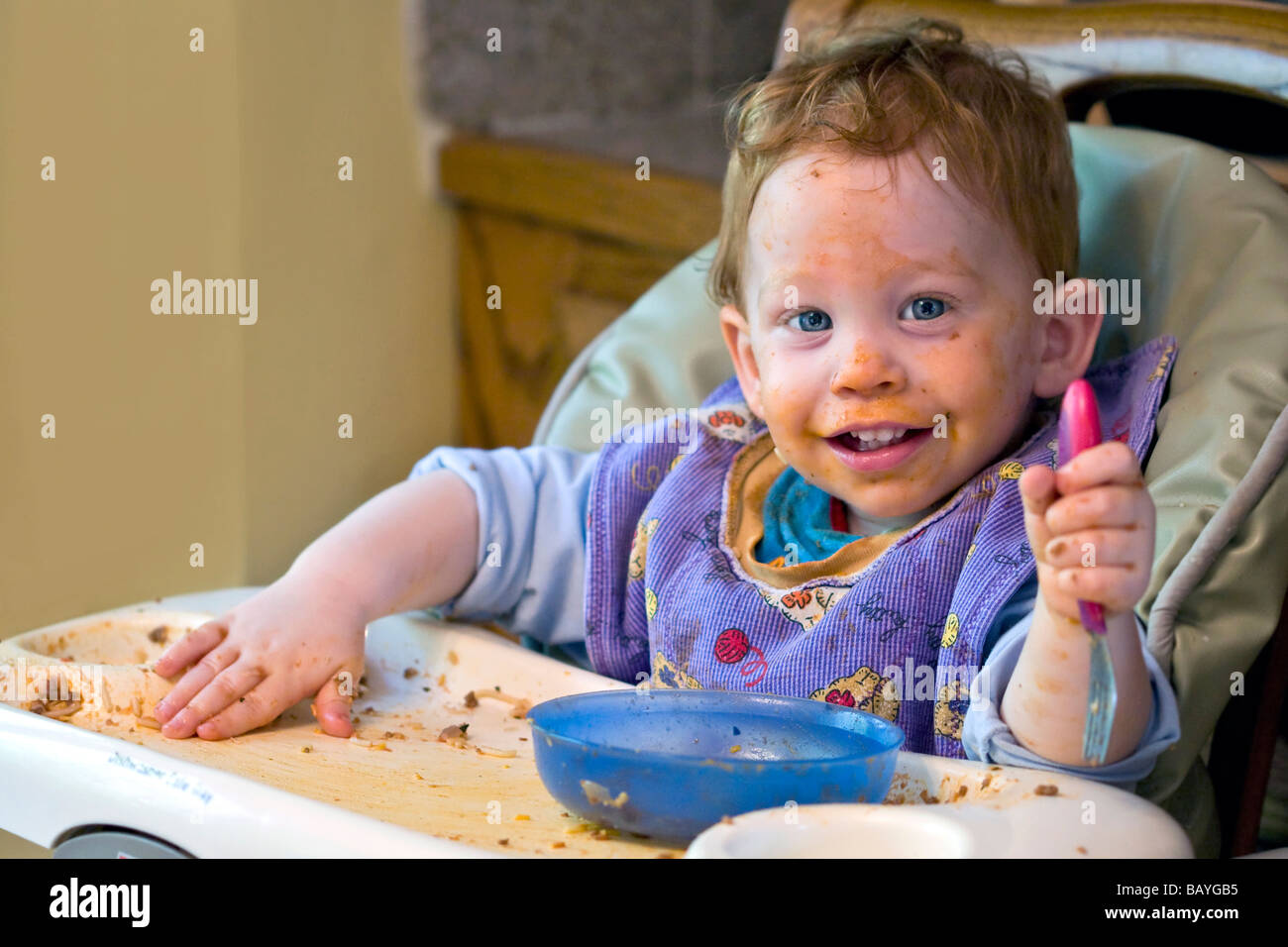 Messy baby covered in food during mealtime Stock Photo - Alamy
