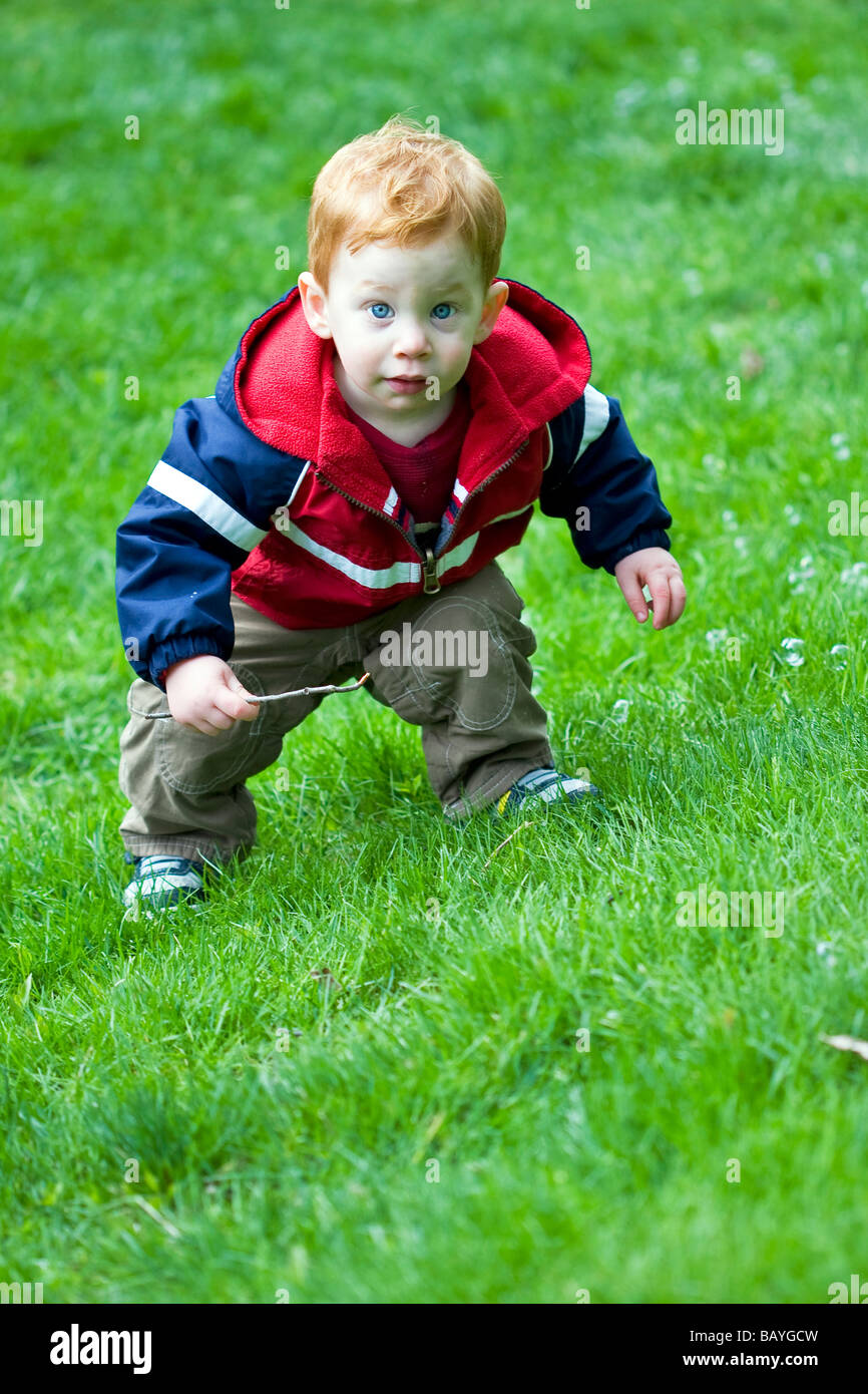 Baby boy exploring grass outside Stock Photo - Alamy