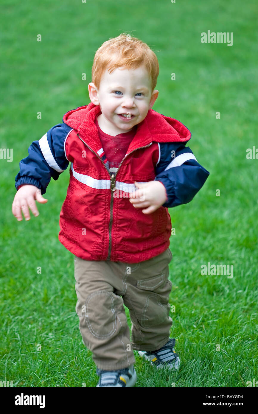 Happy boy running and playing outside on grass Stock Photo - Alamy