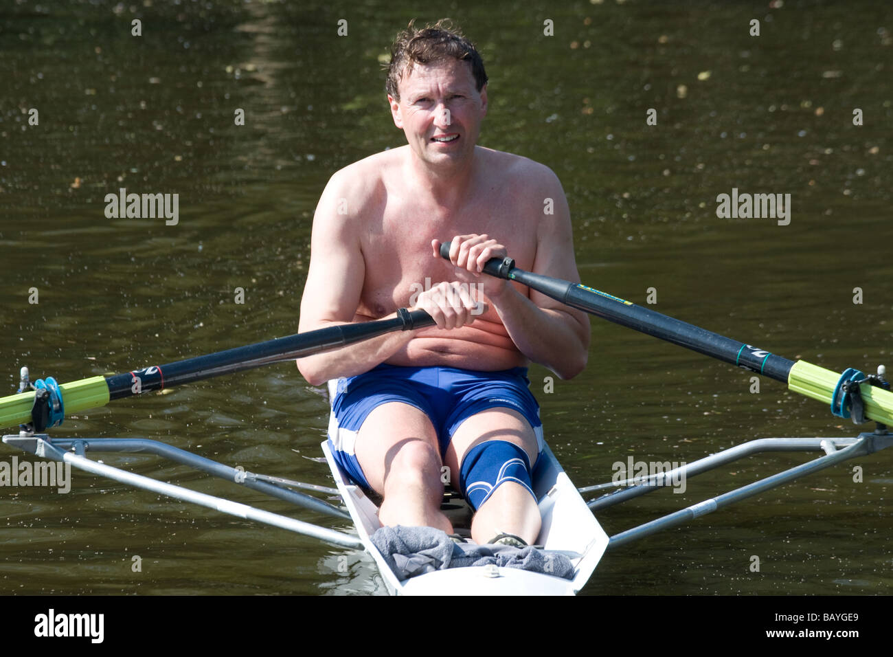 row rowing scull oars canoeist middle aged man Stock Photo - Alamy
