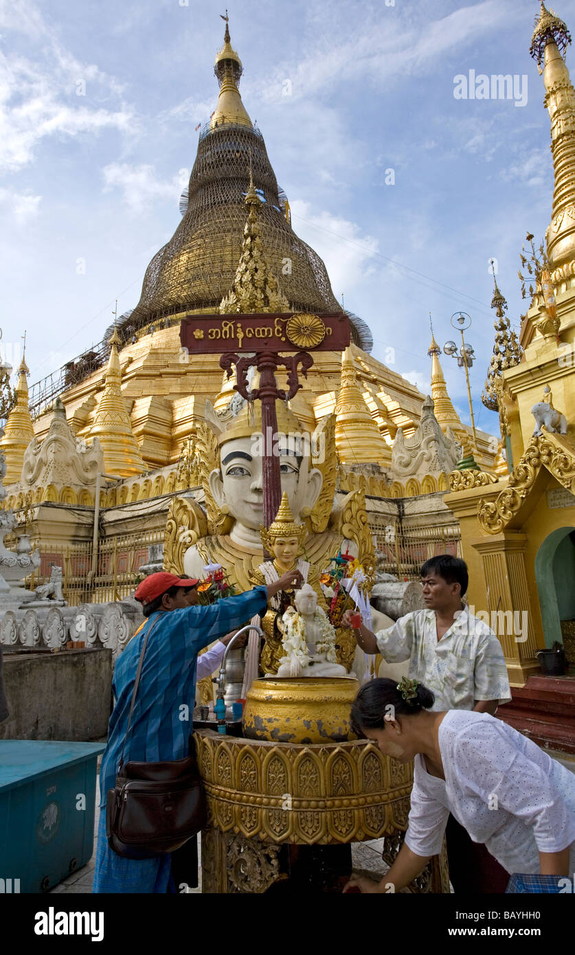 Burmese devotees pouring water and making offerings to Buddha ...