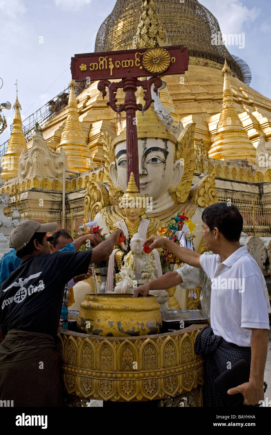 Burmese devotees pouring water and making offerings to Buddha ...