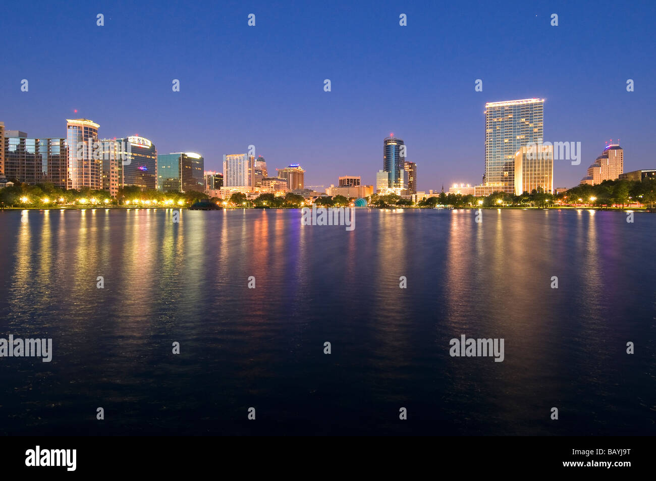 Glowing nighttime downtown skyline of Orlando Florida reflects in Lake ...