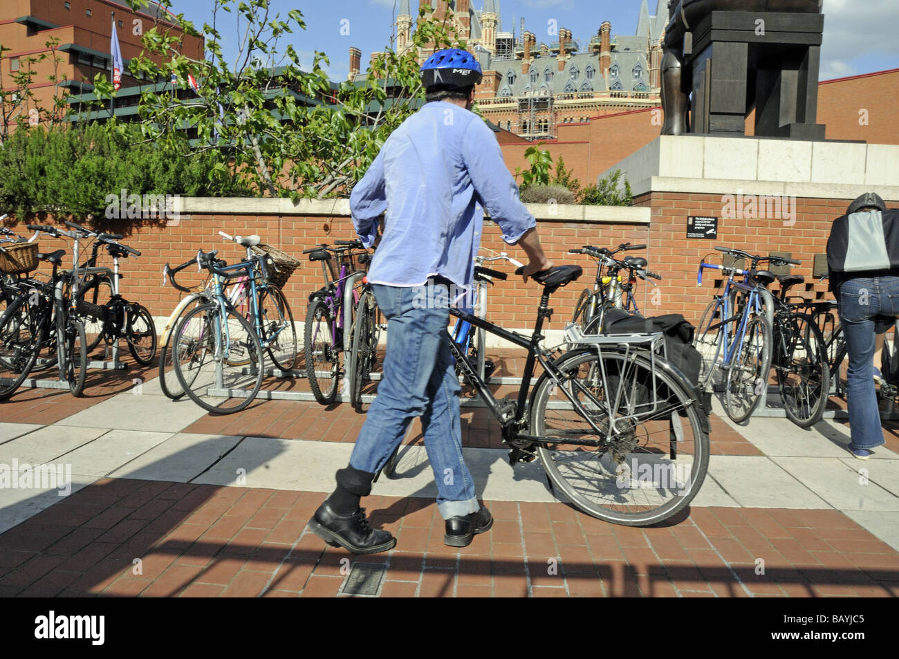 Cyclist parking his bike in the grounds of the British Library Euston ...