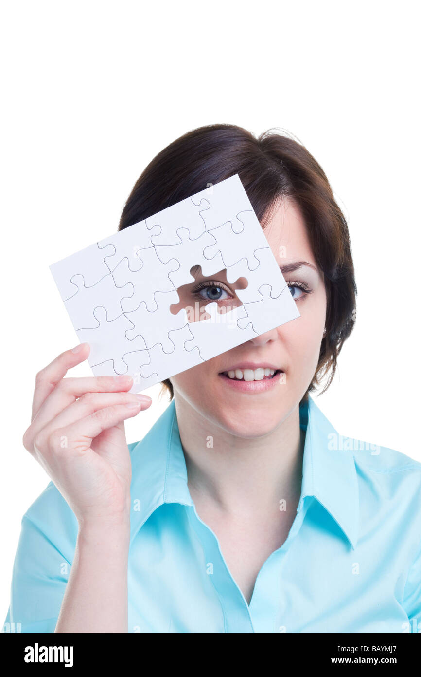 Woman looking through the missing piece of a jigsaw puzzle isolated on ...