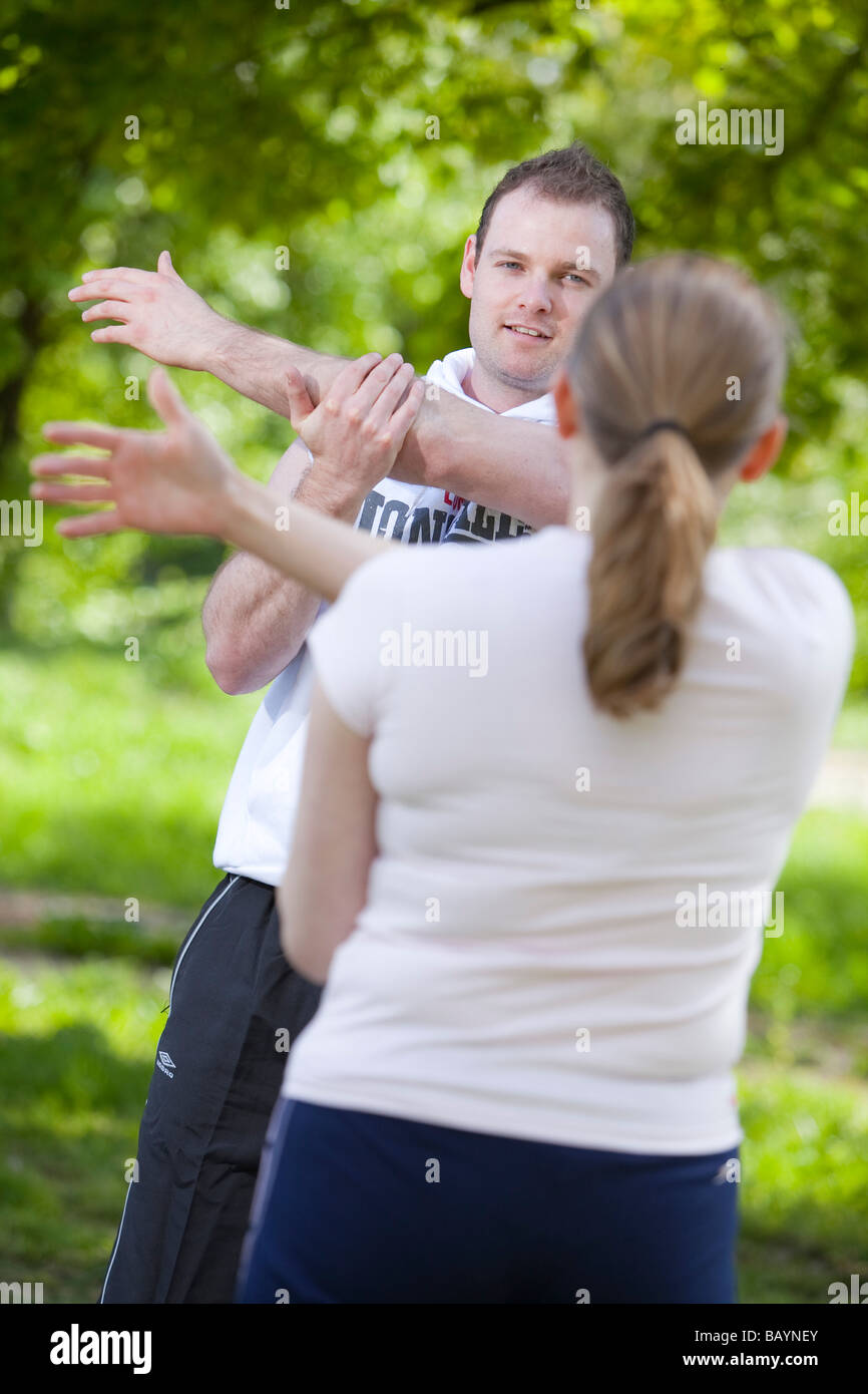 A male physical training instructor with a female student outside ...
