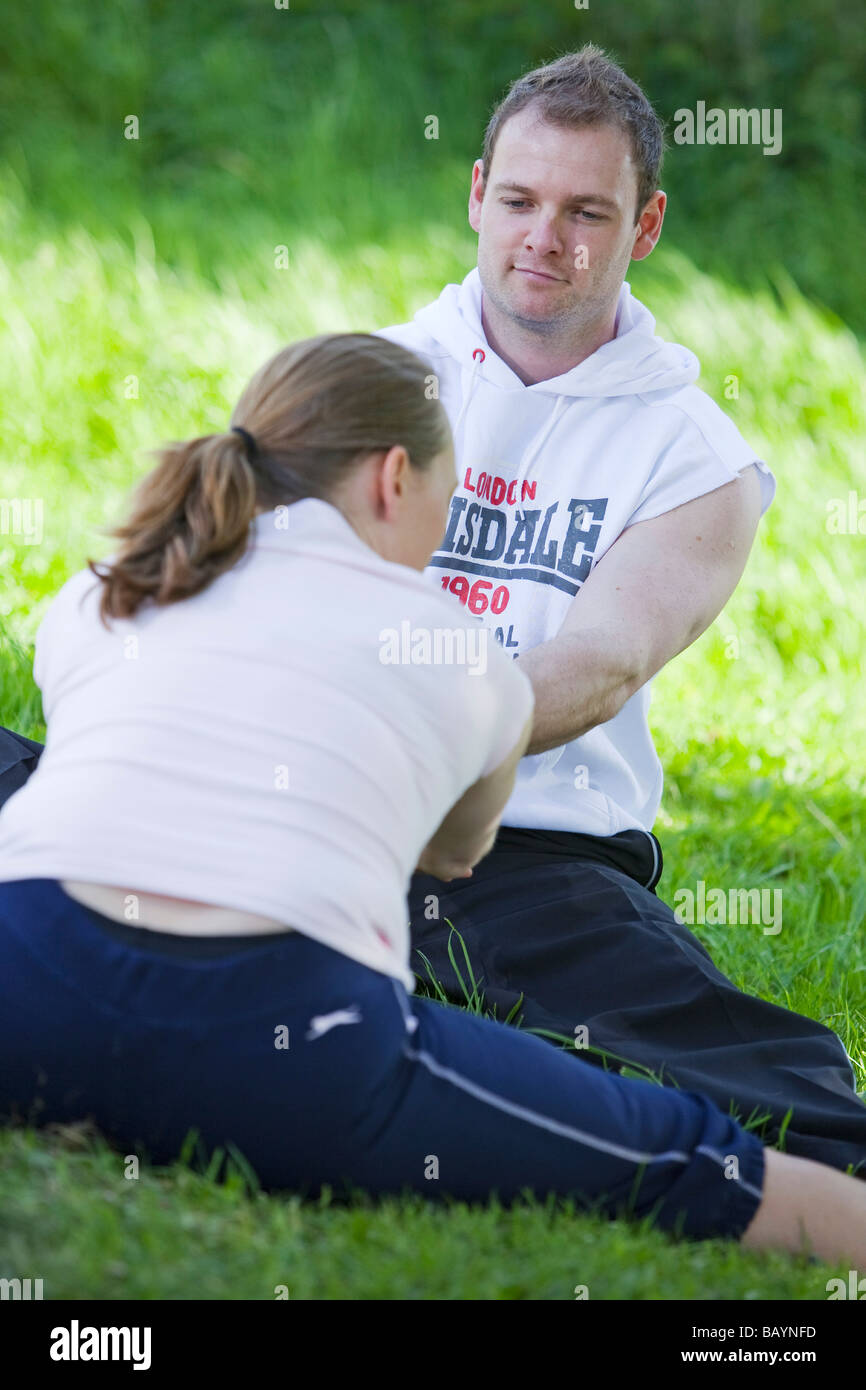 A male physical training instructor with a female student outside ...