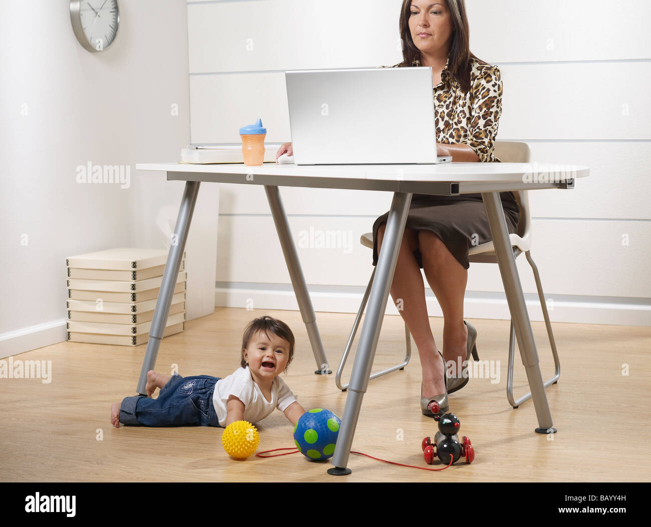 Hispanic working mother and baby son in home office Stock Photo - Alamy