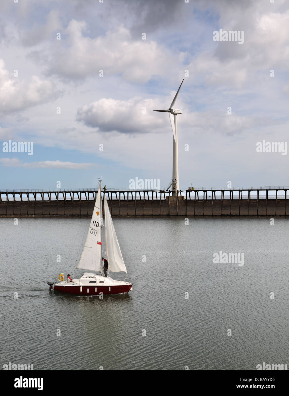 A yacht passes a wind turbine in Blyth harbour, England, UK Stock Photo ...
