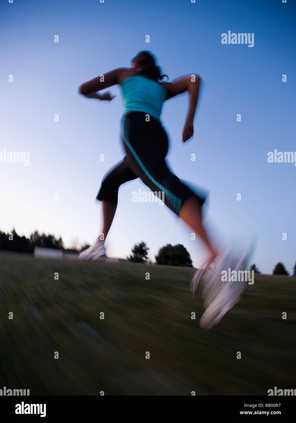Mixed race woman running on grass Stock Photo - Alamy