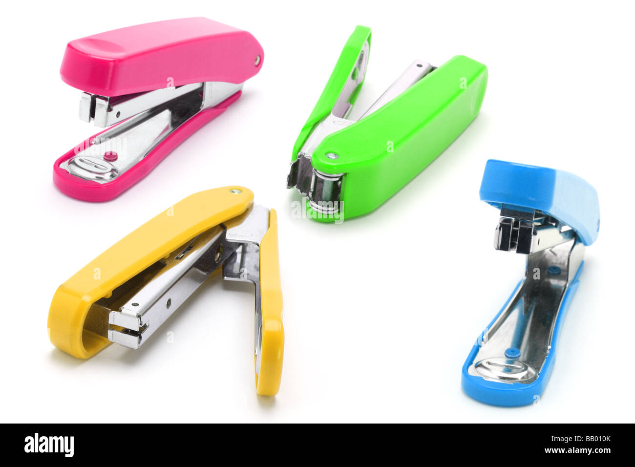 Four colorful staplers arranged on white background Stock Photo - Alamy