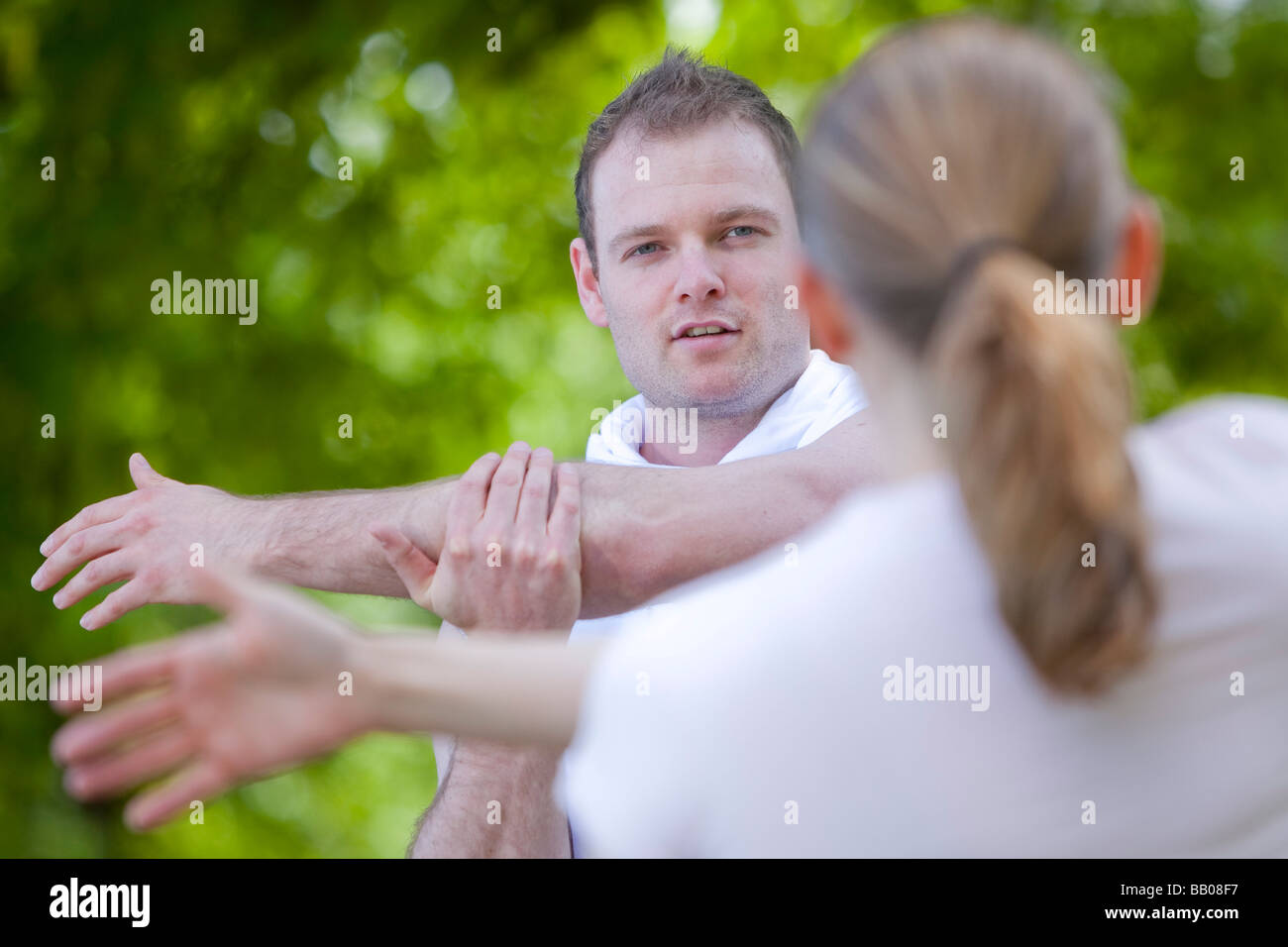 A male physical training instructor with a female student outside ...
