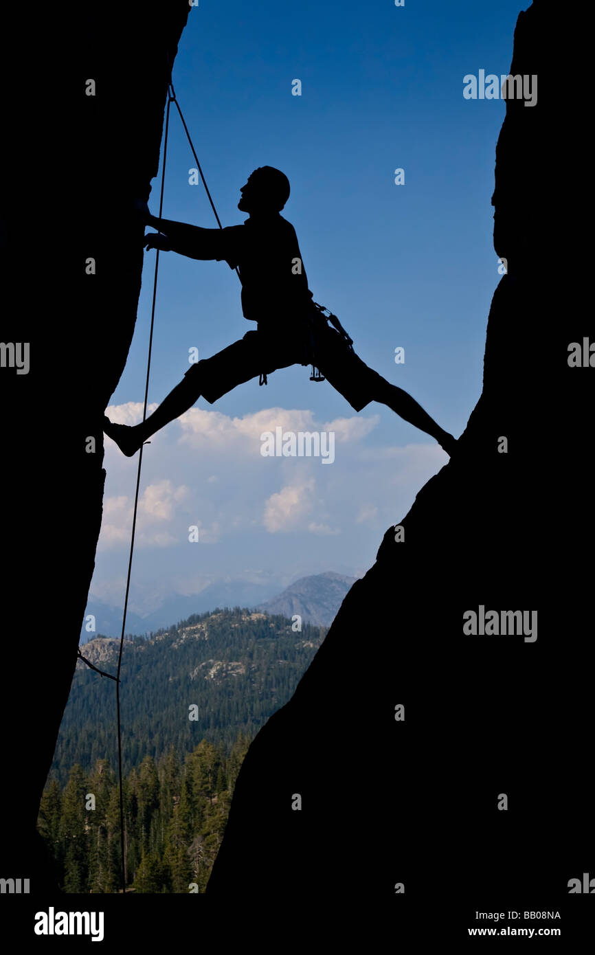 A rock climber is silhouetted as he climbs up a chimney Stock Photo - Alamy