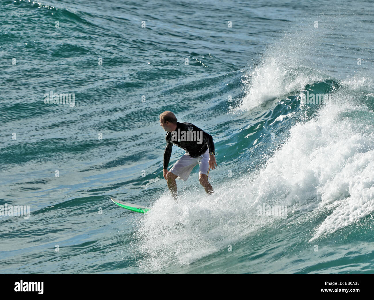 Surfers with surfboards catching waves Stock Photo - Alamy
