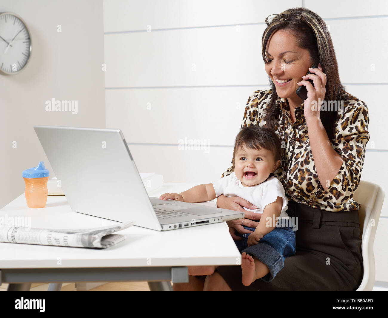 Hispanic working mother holding baby son and talking on phone Stock ...