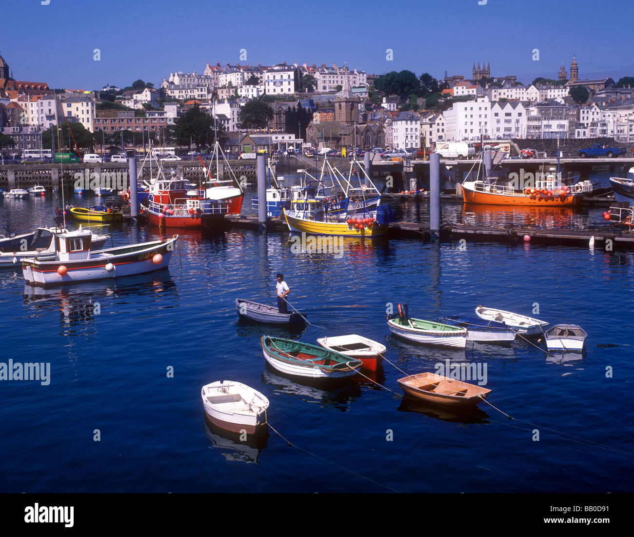 View of the town of St Peter Port from across the fishing boat harbour ...
