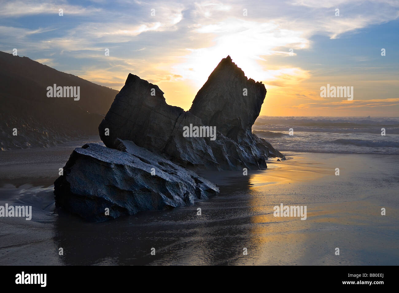 big black rock on sunset sea background Stock Photo - Alamy