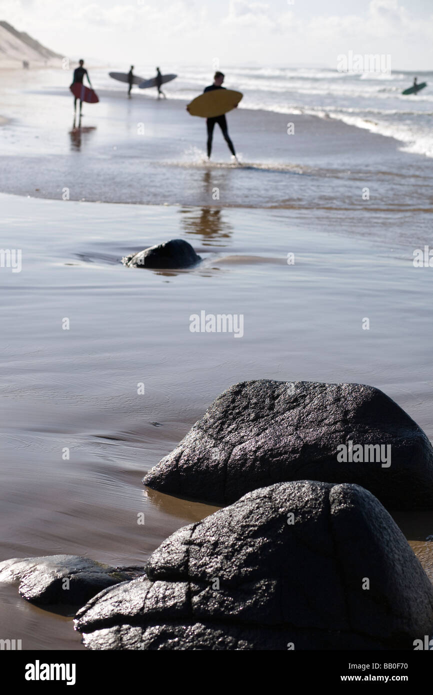 Surfers On A Beach Stock Photo - Alamy