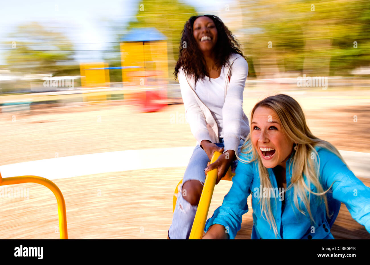 Black and white women having fun on park ride smiling african american ...