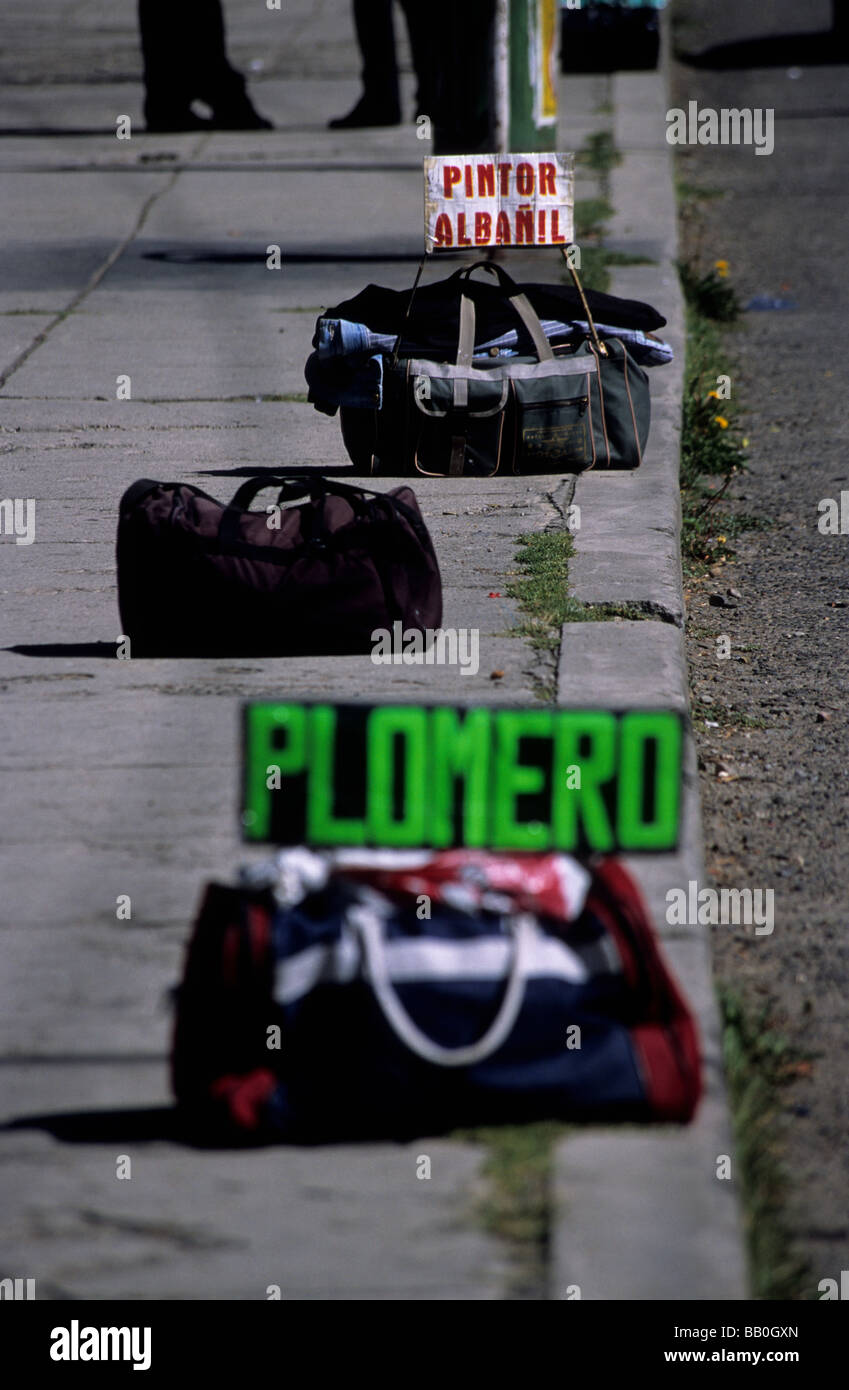 Bags of workers waiting for work on pavement (telephoto lens, focus in ...