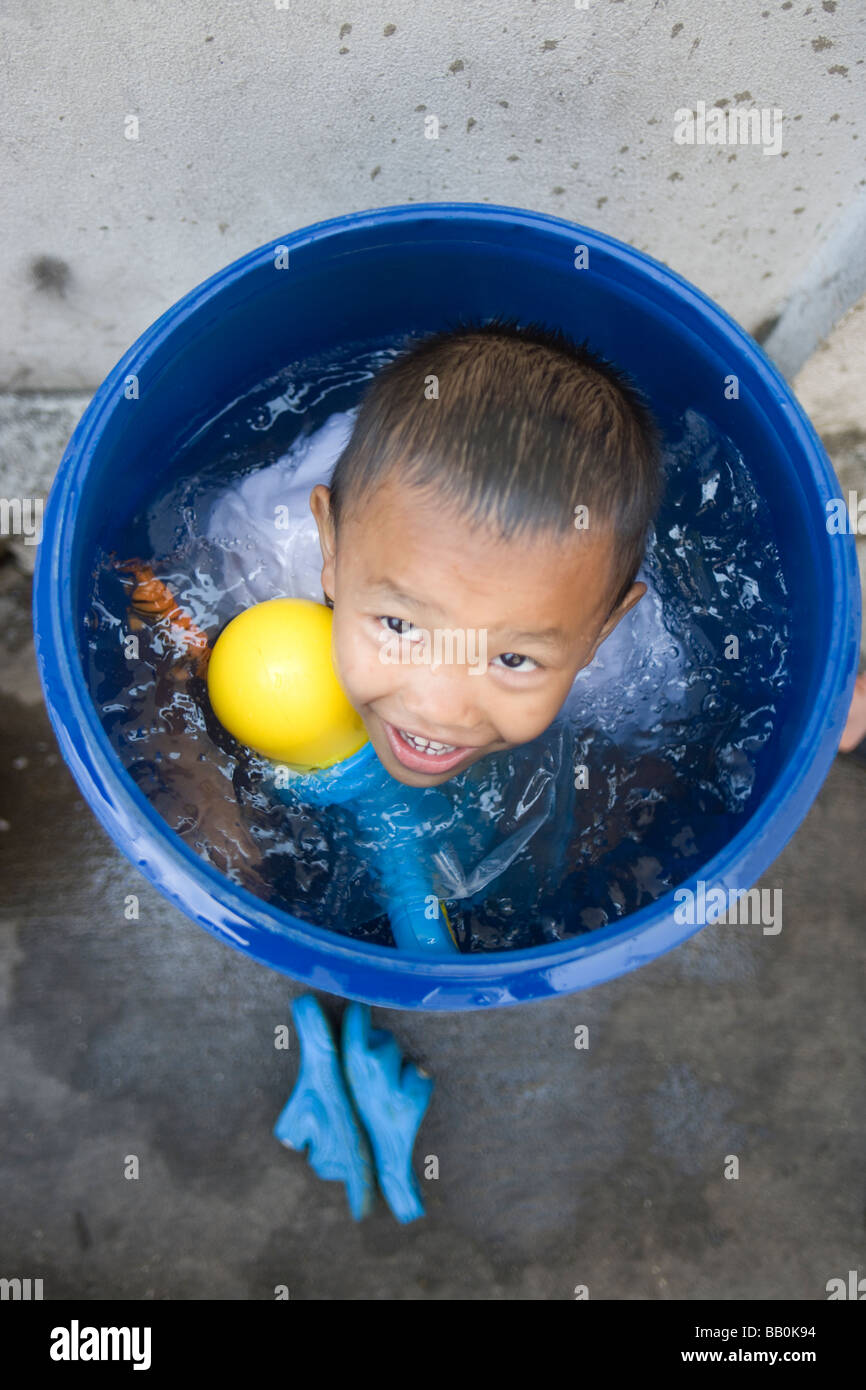 Boy in a bucket during the Thai Songkran celebrations Stock Photo - Alamy