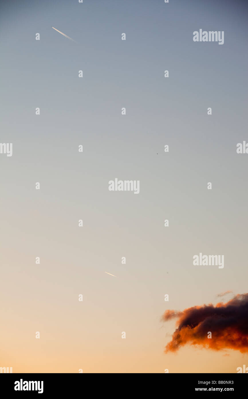 A plane flying through sunset clouds over Ambleside Lake District UK ...