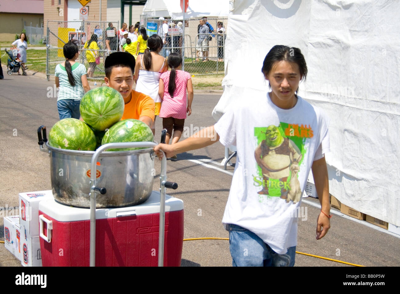 Hmong teen boys cart melons and food to supply outdoor restaurant ...