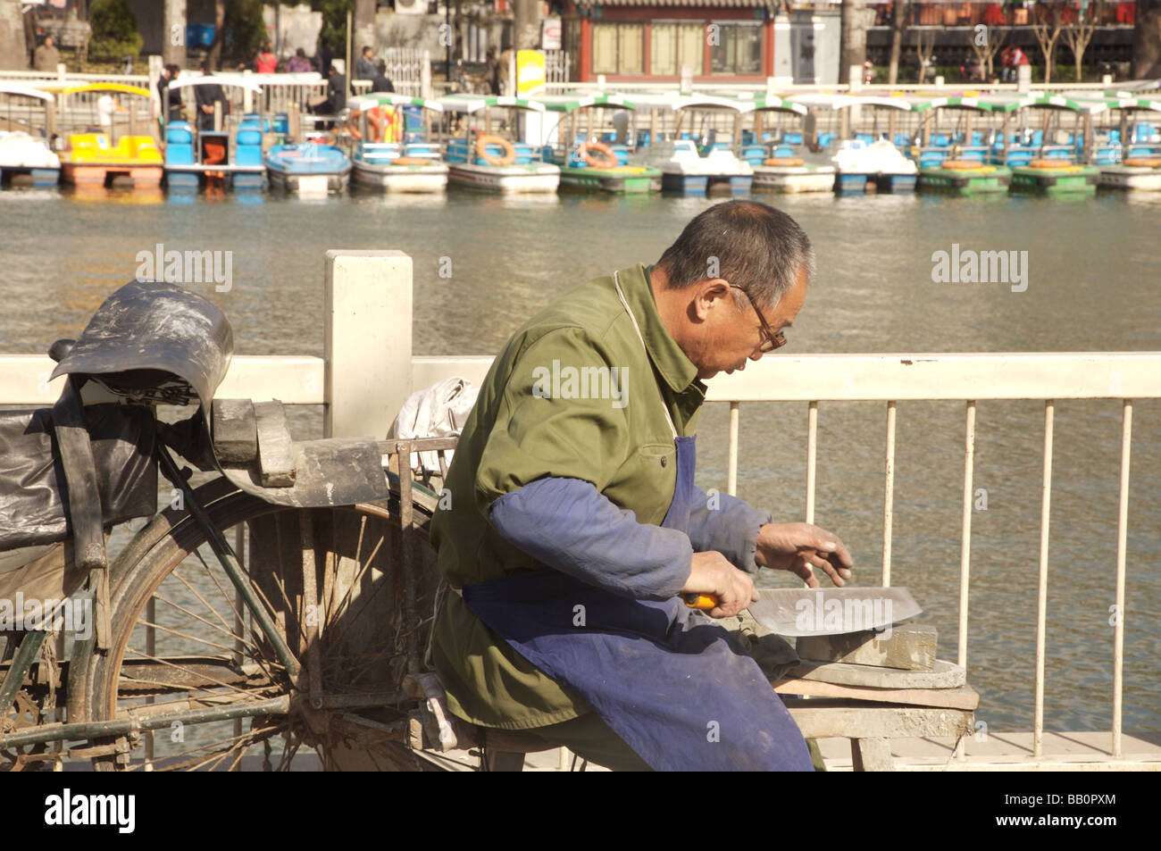 Man sharpening knife on street in Beijing China Stock Photo - Alamy