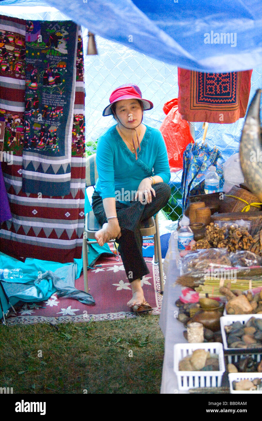 Hmong merchant resting and rubbing tired feet during a busy day at her ...