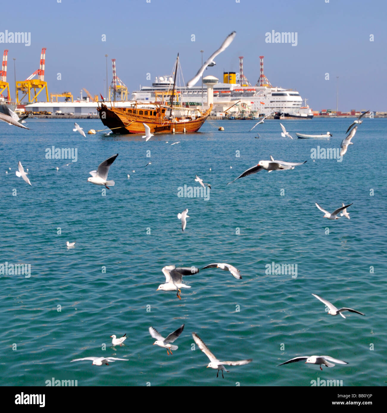 Muscat Dhow moored in Muttrah harbour in seascape with Costa cruise ...