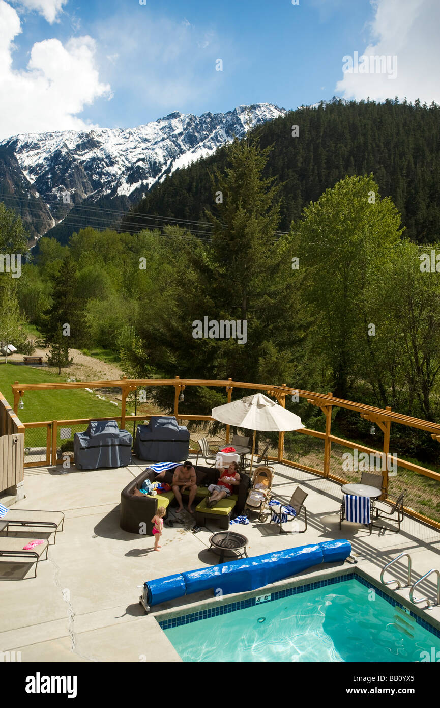 Hotel guests enjoy the sun pool side with Mt Currie in the background ...