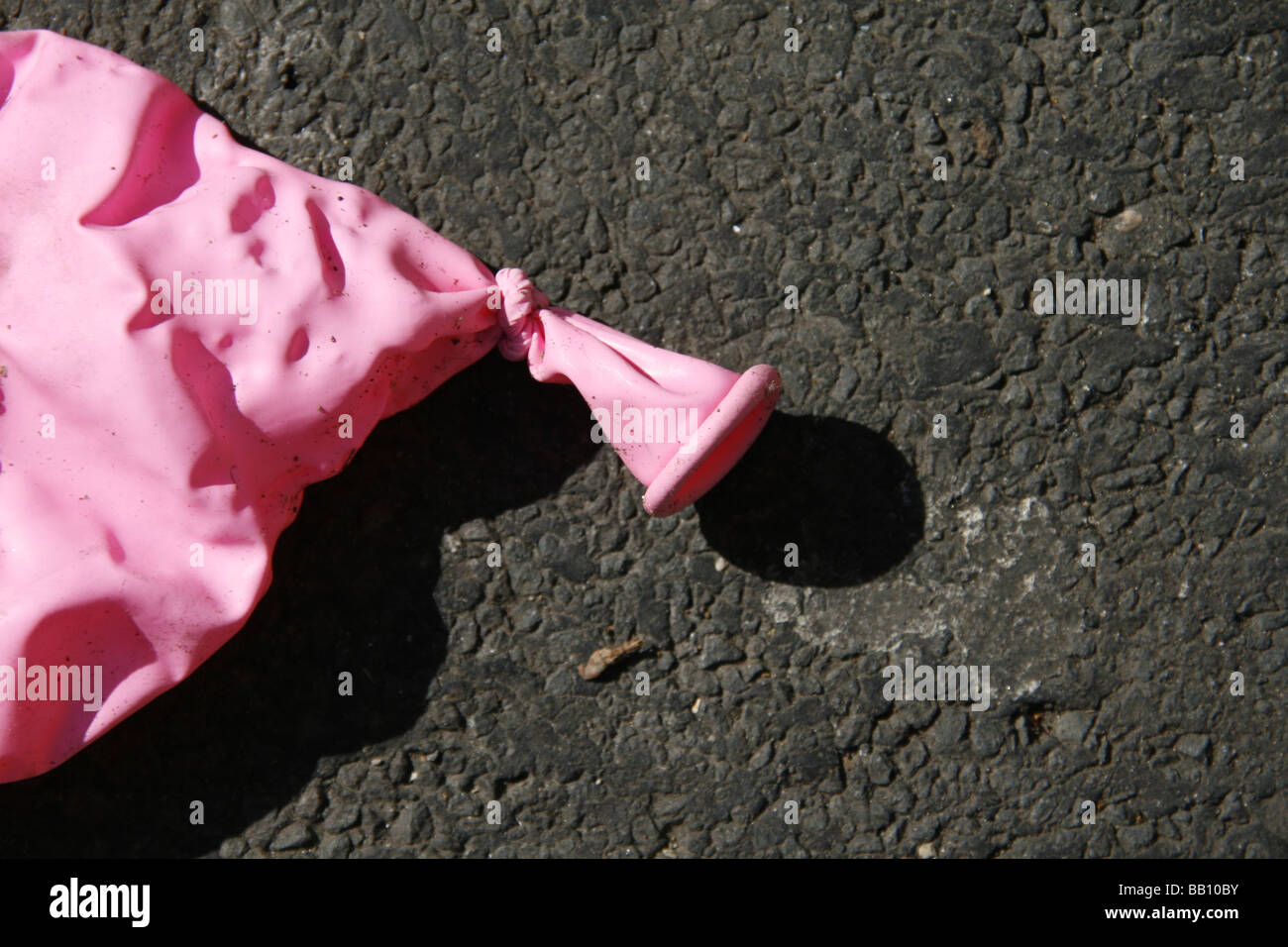 close up detail of one burst pink balloon on floor ground Stock Photo ...