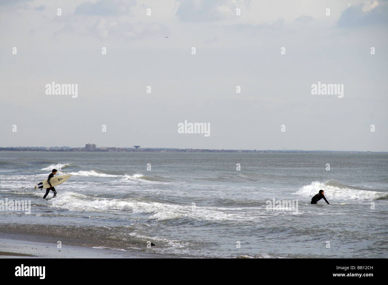 two surfers entering sea waves in ostia italy Stock Photo - Alamy