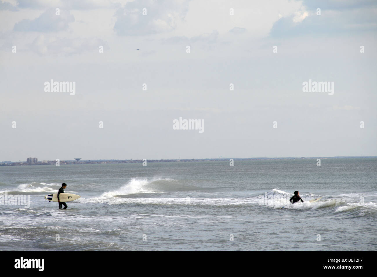 two surfers entering sea waves in ostia italy Stock Photo - Alamy
